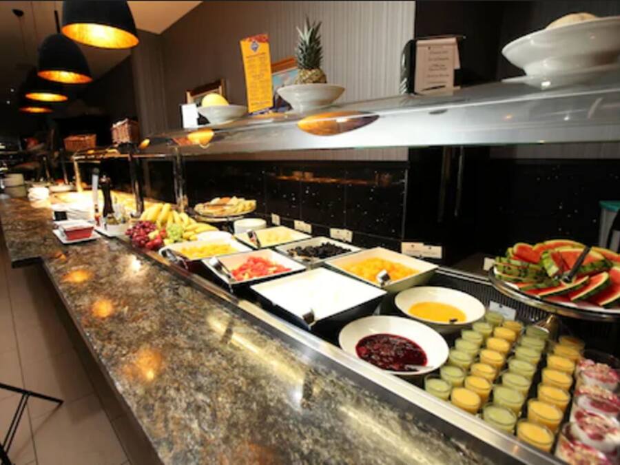 Buffet com diversos alimentos e uma abacaxi no balcão.