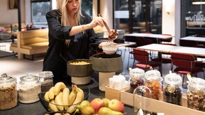 Alguém preparando comida em um balcão, com diversos alimentos e recipientes.