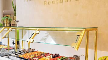 Buffet no Restaurante Atmosphere com variedade de alimentos e uma vitrine de vidro em moldura dourada.