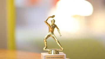 Um troféu sobre uma mesa com fundo desfocado.