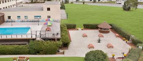 Vista aérea de um hotel com piscina, área de estar ao ar livre e estacionamento.