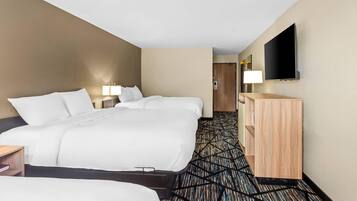 Quarto de hotel com duas camas, uma televisão de tela plana, cômoda de madeira e tapete estampado.
