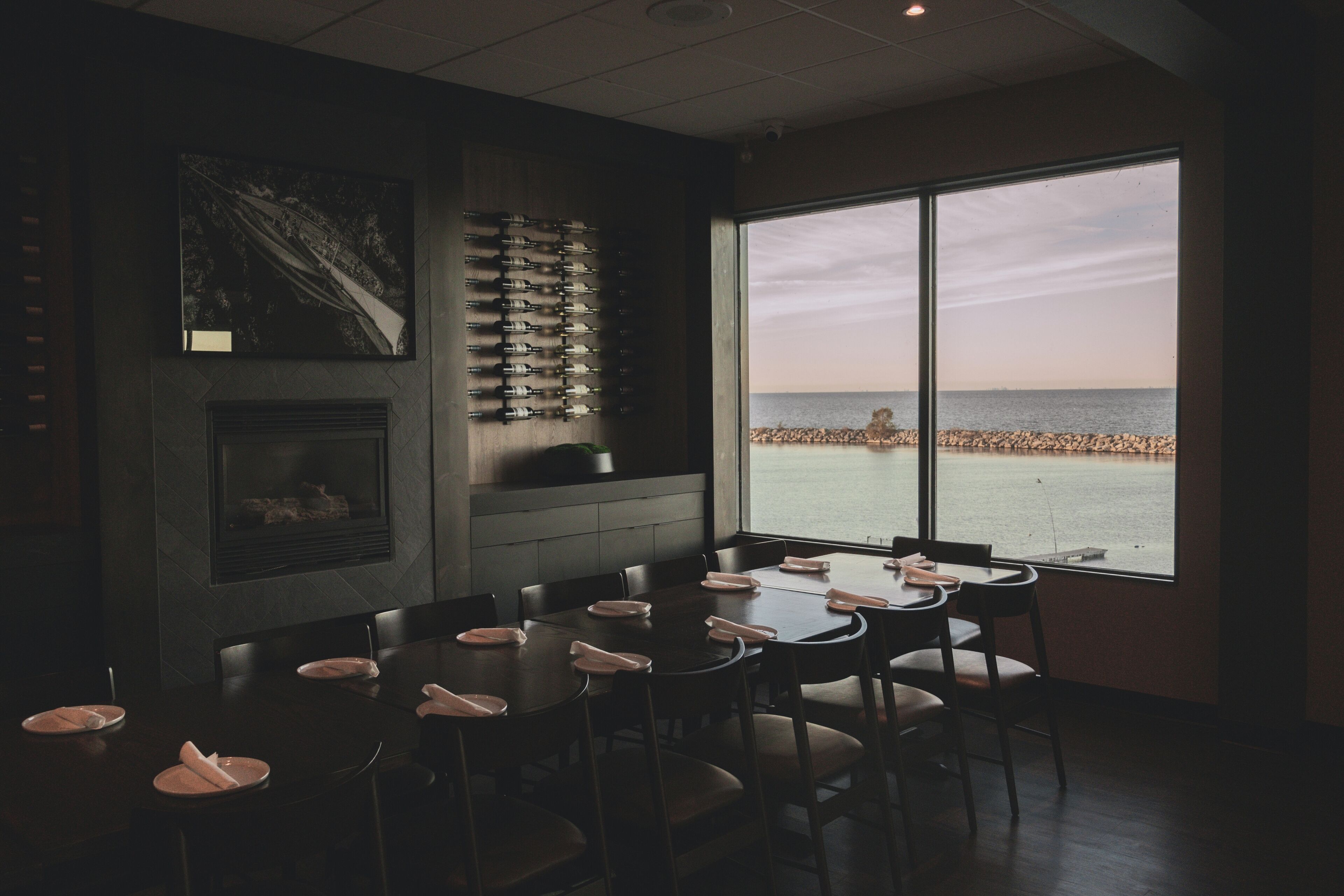 Um restaurante com uma grande janela com vista para um litoral rochoso.