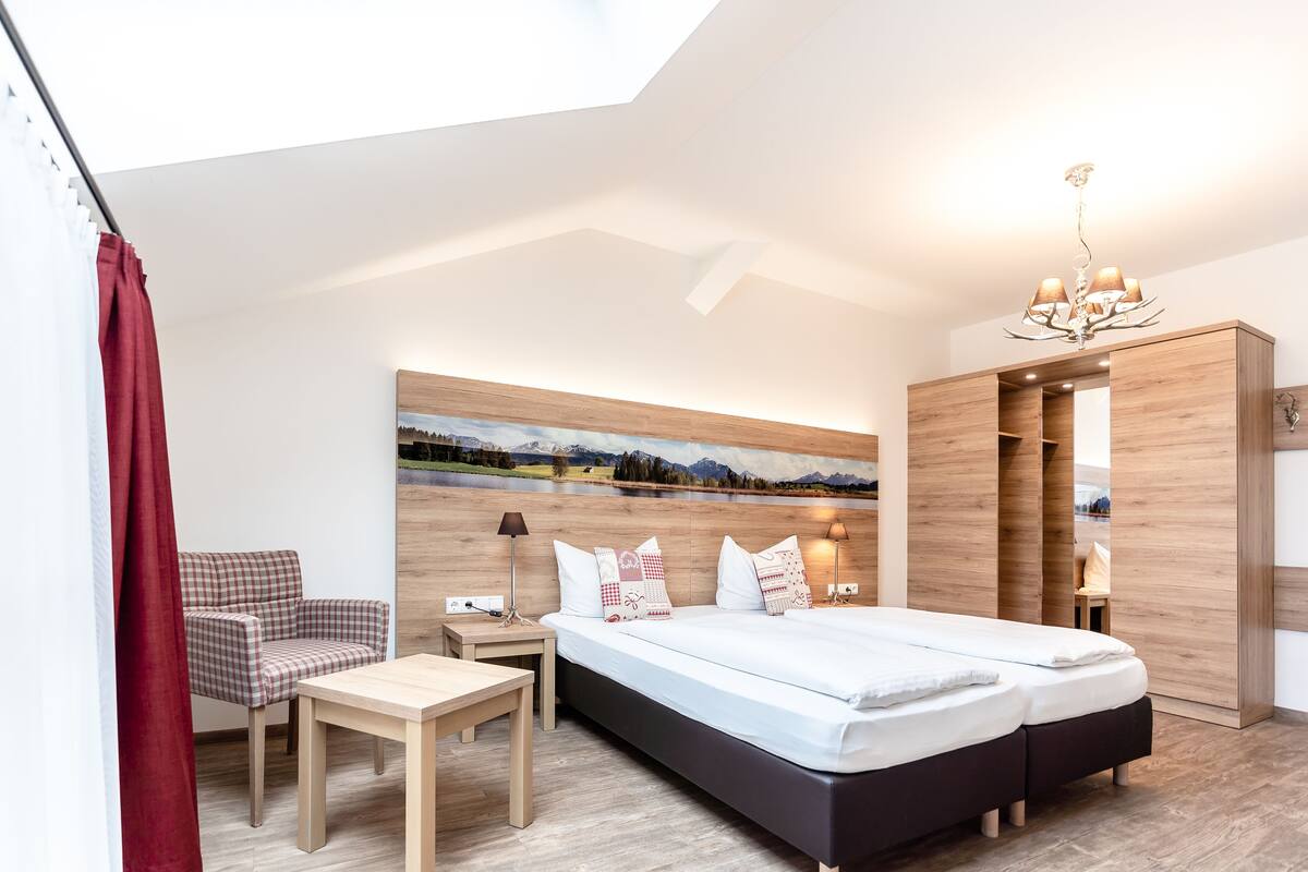 Quarto com cama, escrivaninha, cadeira, guarda-roupa e um quadro na parede.