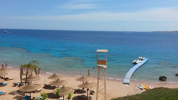 Uma praia privada, espreguiçadeiras, guarda-sóis de praia
