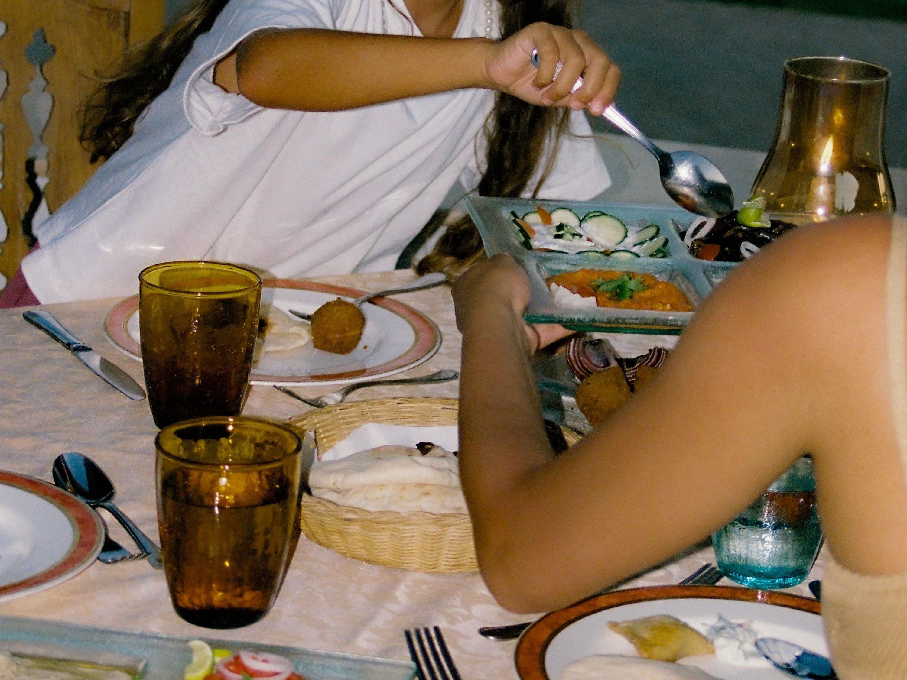Mesa de jantar com pratos, talheres e copos, sugerindo uma refeição.