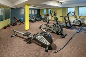 Uma academia com diversos equipamentos de exercício, incluindo esteiras, bicicletas ergométricas e aparelhos de musculação.
