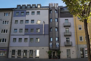 Hotel de vários andares com fachada moderna, apresentando varandas e uma variedade de estilos de janelas.