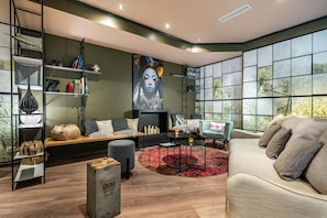 Uma sala de estar moderna com uma janela ampla, uma estante, um sofá e uma mesa de centro.