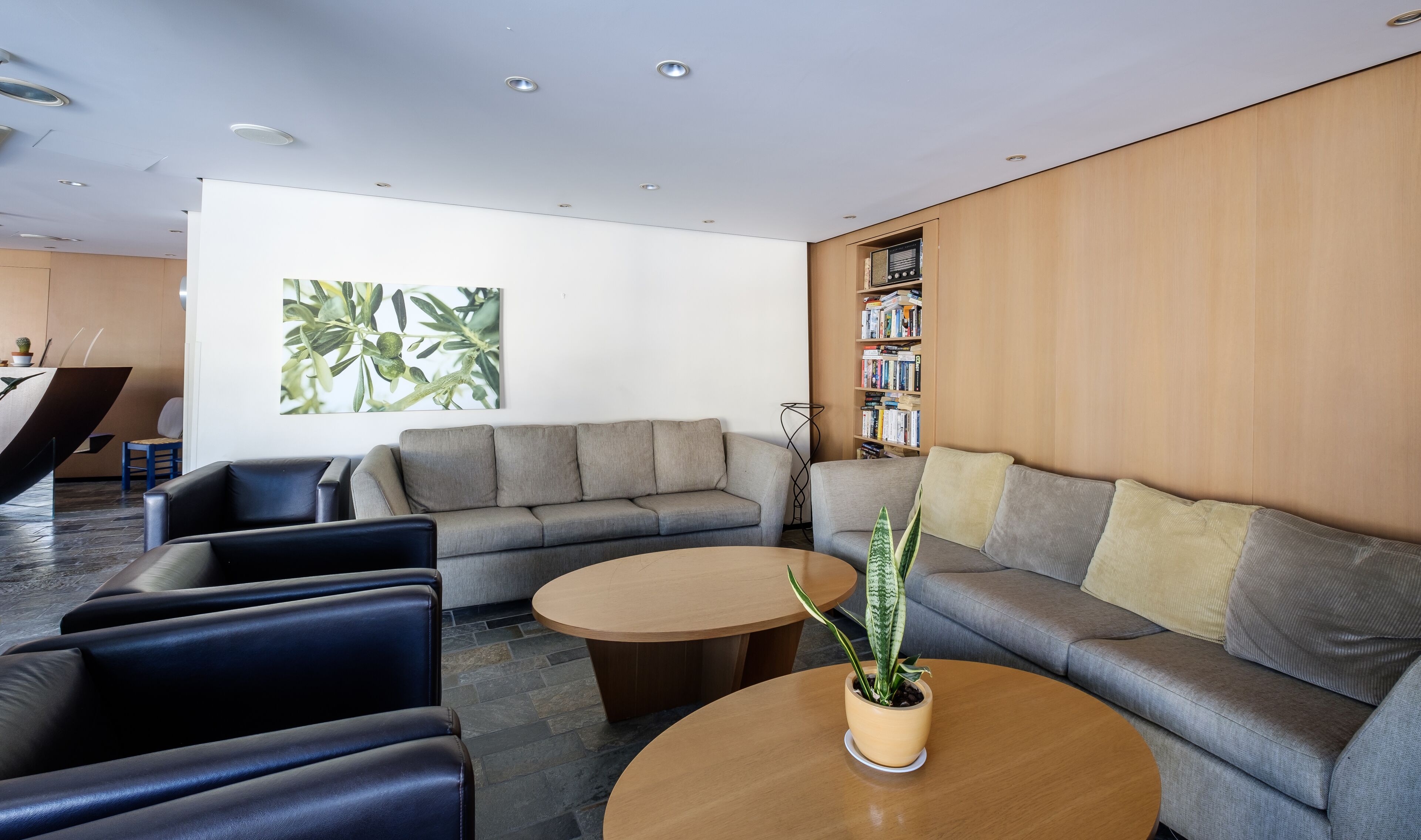 Uma área de estar moderna com sofás, uma mesa de centro e uma estante.