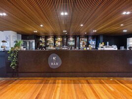 Um bar com teto de madeira e balcão de mármore.