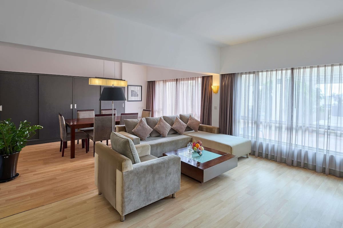 Uma sala de estar moderna com sofá, mesa de centro e área de jantar.