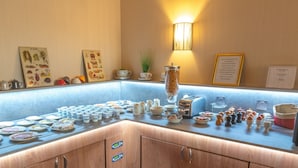 Um buffet de café da manhã com diversos alimentos e utensílios.
