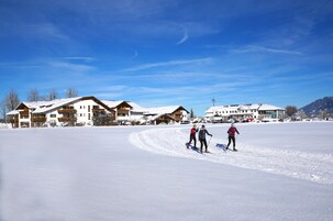 Paisagem coberta de neve com edifícios ao fundo.