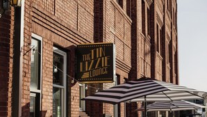 Um edifício de tijolos com uma placa que diz 'The Lizzie Lounge'.