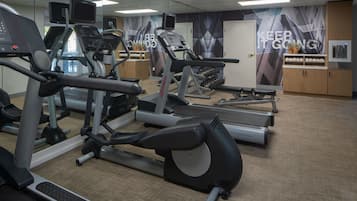 Uma academia com esteiras, elípticos e aparelhos de musculação.