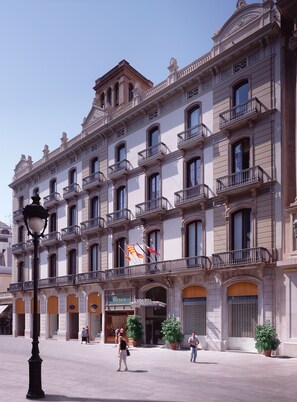 Um edifício histórico com várias varandas e uma entrada central.