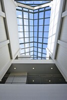 Um átrio moderno com teto de vidro, permitindo que a luz natural ilumine o espaço.