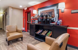 Uma área de recepção com um letreiro 'WELCOME', um espaço para café e um bar de petiscos.