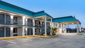Um motel com vários quartos, estacionamento coberto e posto de combustível.