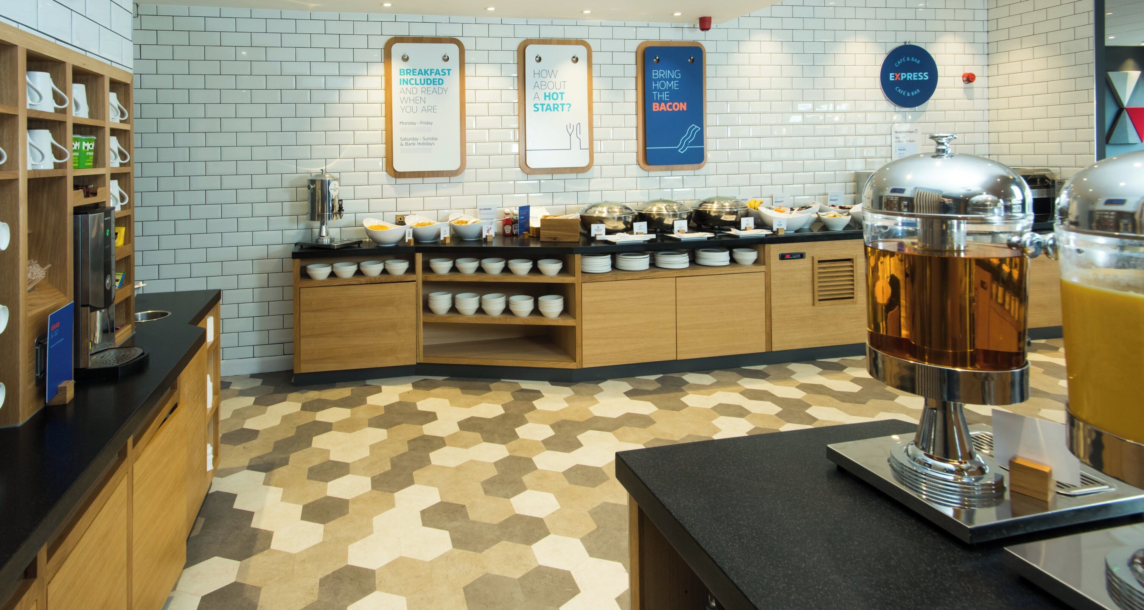 Espaço de buffet de café da manhã com diversas opções de comida e máquina de café.