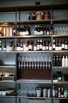 Uma adega com várias garrafas e copos de vinho.