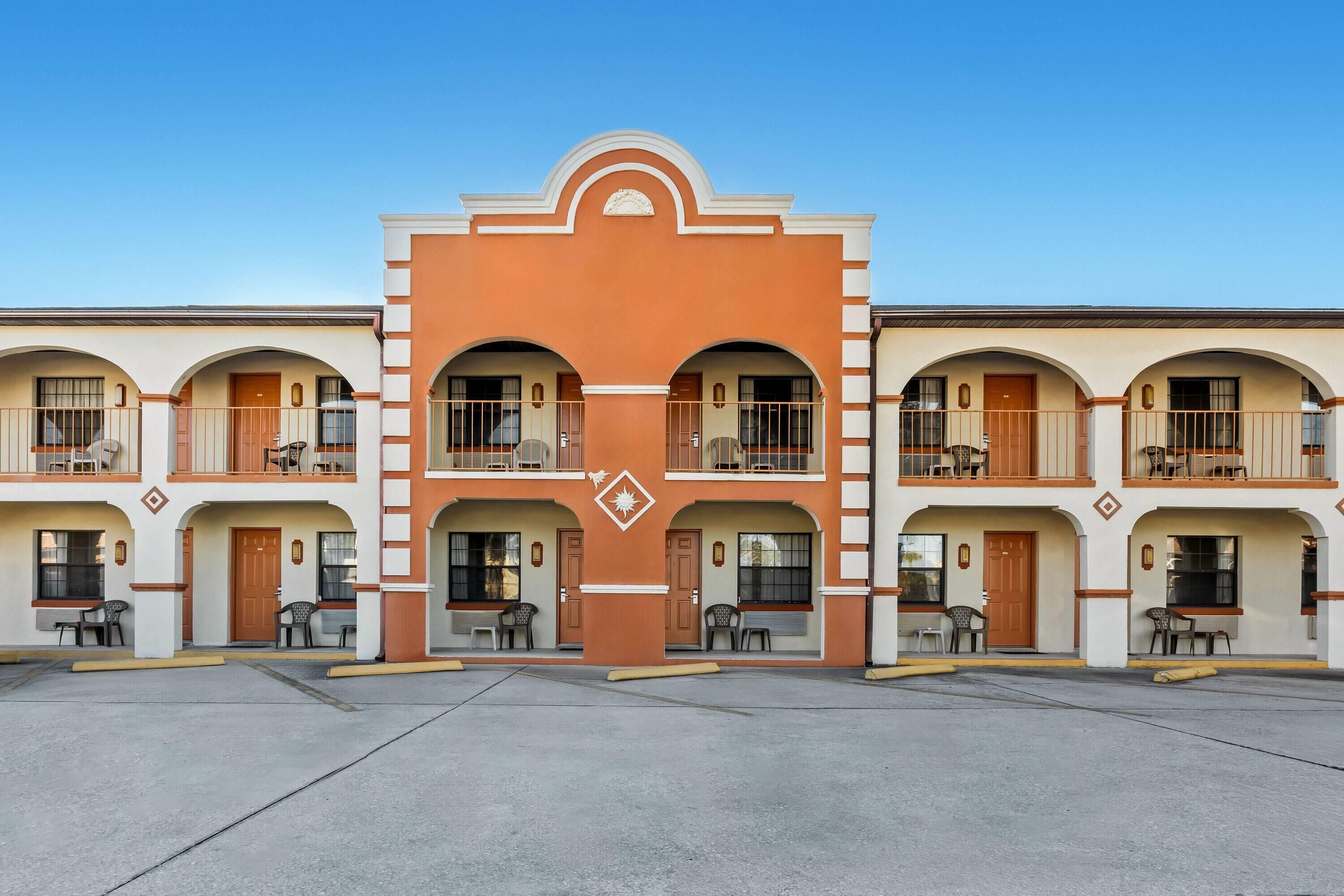 Um hotel com um pátio central, várias varandas e uma fachada simétrica.
