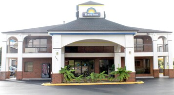 Um Days Inn com estrutura em dois andares, telhado plano e um letreiro da Coca-Cola na lateral.