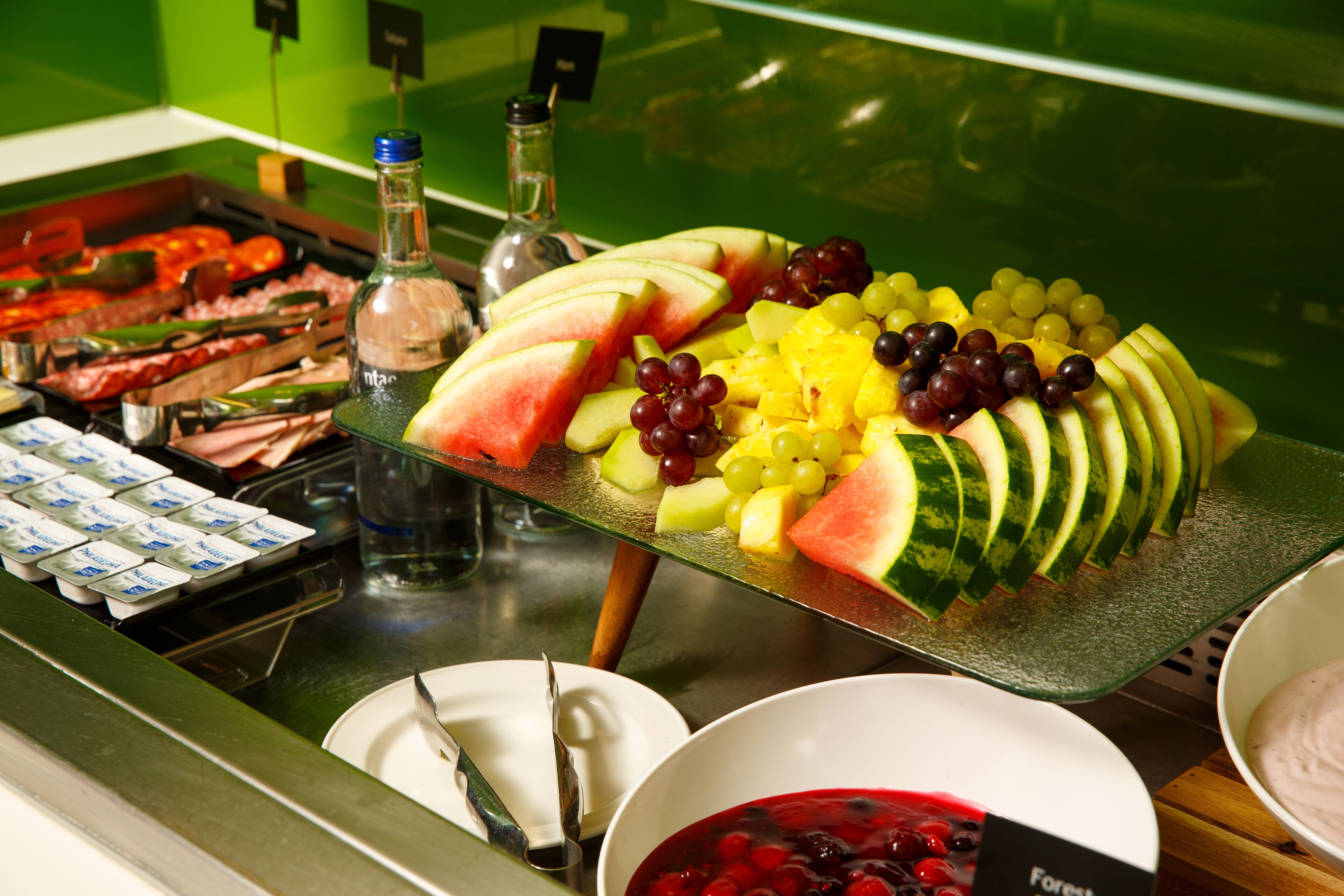 Um buffet com diversas frutas, legumes e carnes.