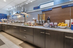 Um balcão de café da manhã com diversos alimentos e recipientes.