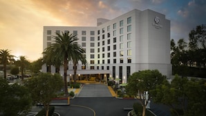 Um hotel moderno com fachada plana, várias janelas e um logotipo em destaque.