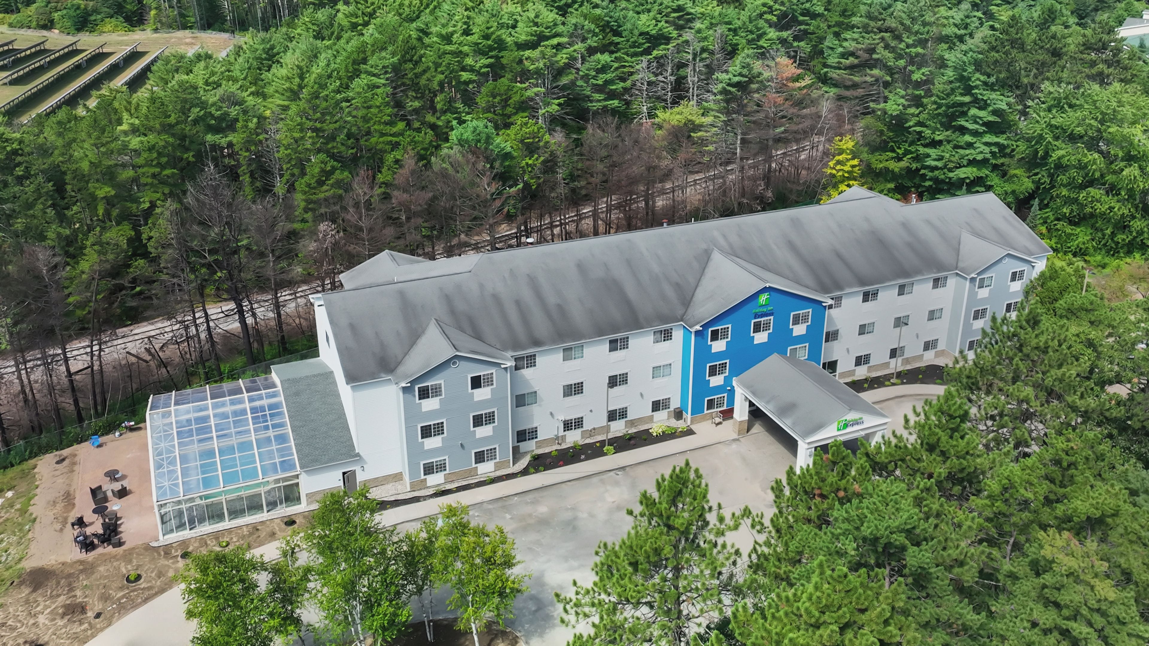 Hotel de vários andares com telhado plano, fachada azul e branca e um painel solar.