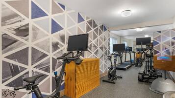 Academia com bicicletas ergométricas, esteiras e parede de painel de madeira.