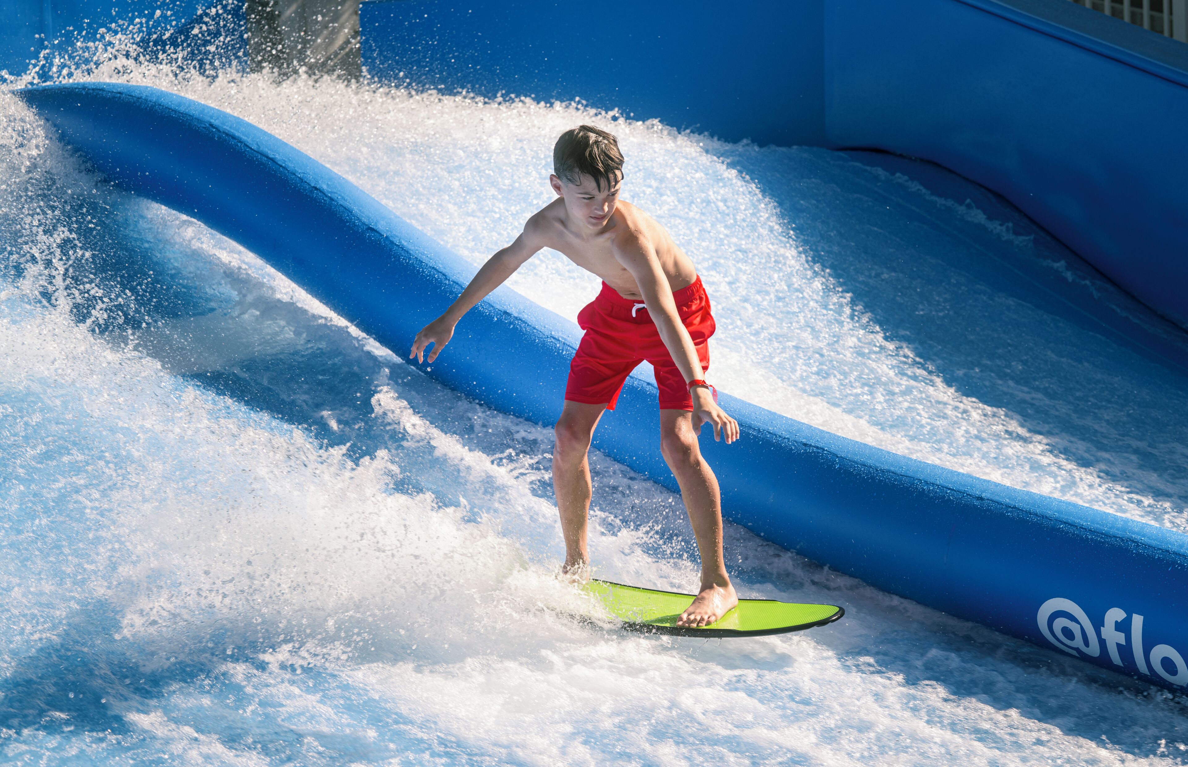Uma pessoa surfando em uma onda em um parque aquático.