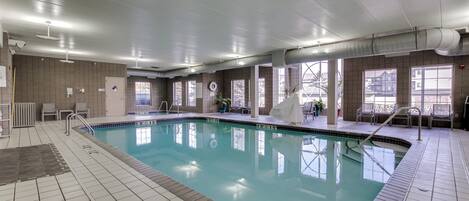 Piscina interna com água cristalina, paredes e piso revestidos em azulejo.