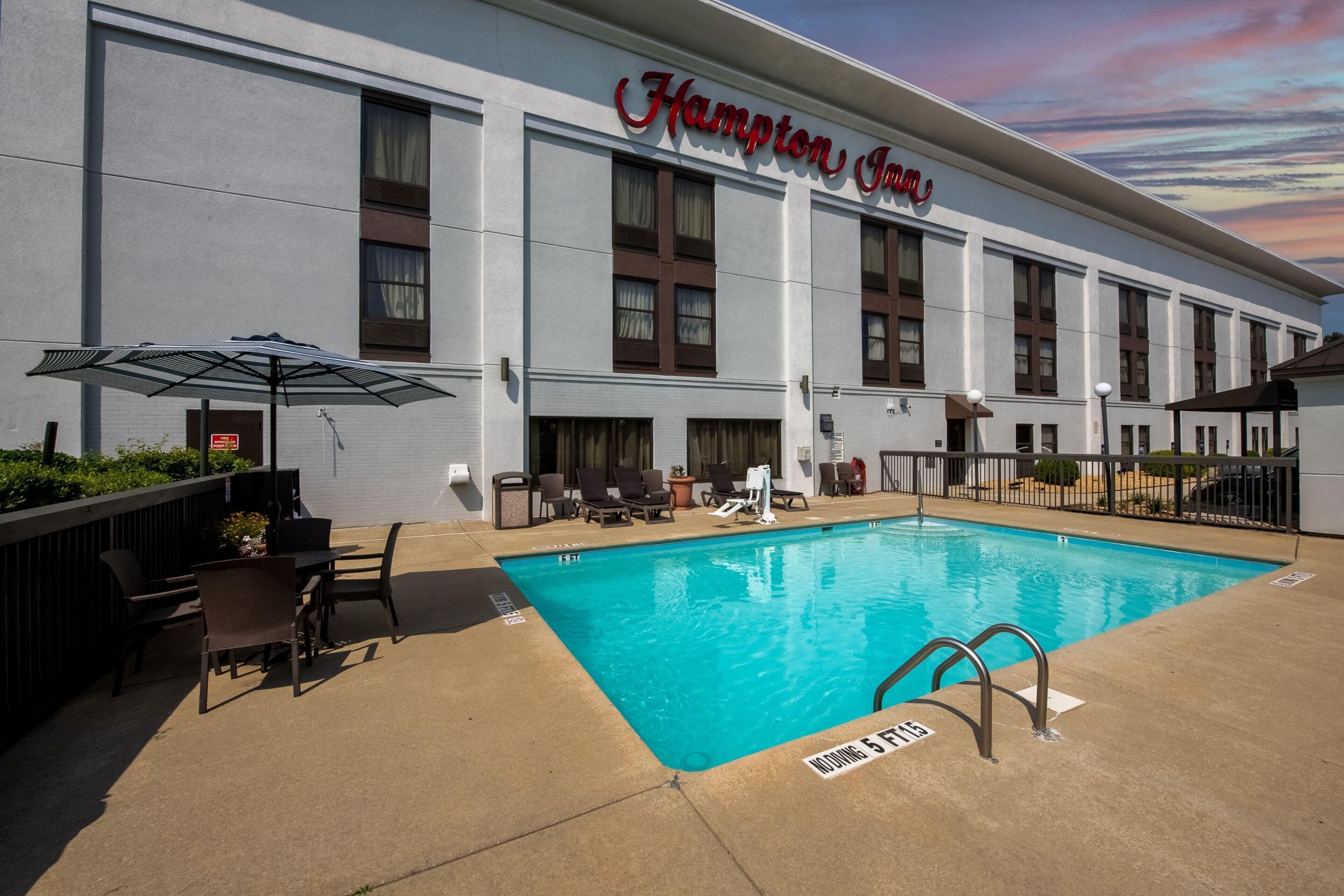 Hotel Hampton Inn com piscina, área de estar externa e céu limpo.