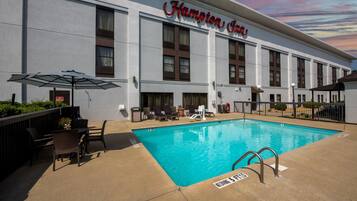 Hotel Hampton Inn com piscina, área de estar externa e céu limpo.