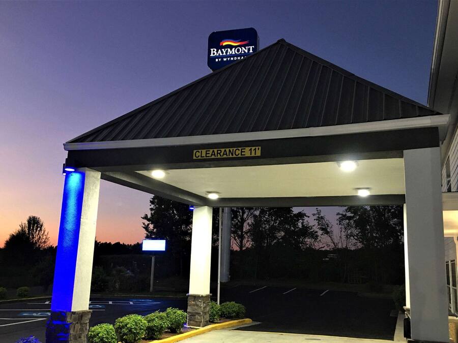 Hotel Baymont by Wyndham com área de estacionamento coberta e placa indicando altura máxima de 3,35 metros.
