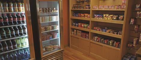 Uma área de autoatendimento com diversas opções de lanches e bebidas, incluindo refrigerantes e alimentos embalados.