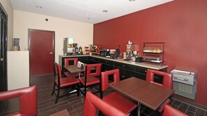Restaurante com cadeiras vermelhas e um balcão com alimentos.
