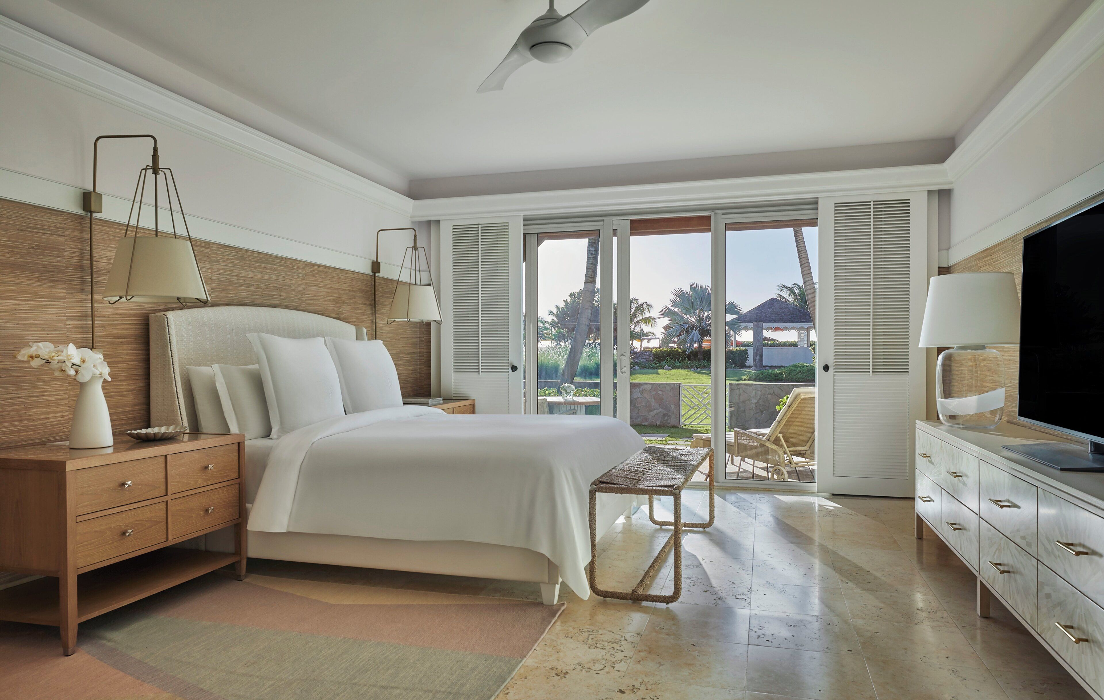 Quarto de hotel com uma cama, mesas de cabeceira, uma TV e vista para o exterior.