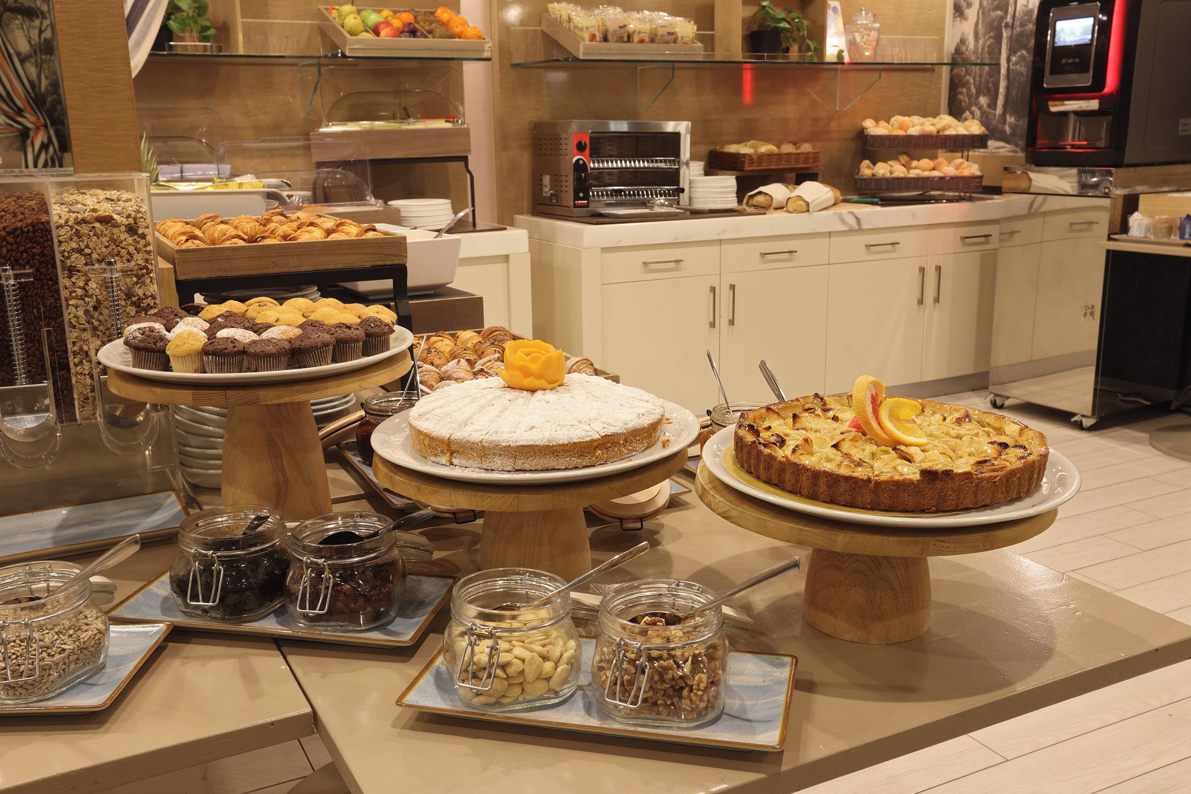 Buffet com diversos pastéis, bolos e sobremesas à mostra.