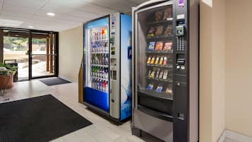 Uma área com máquinas de venda automática, incluindo um dispensador de água e uma máquina de snacks.