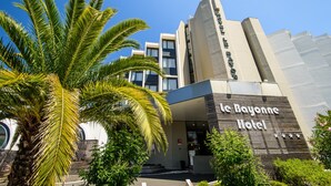 Um hotel com design moderno, apresentando uma entrada imponente e uma placa com a inscrição 'Le Bayonne Hotel'.