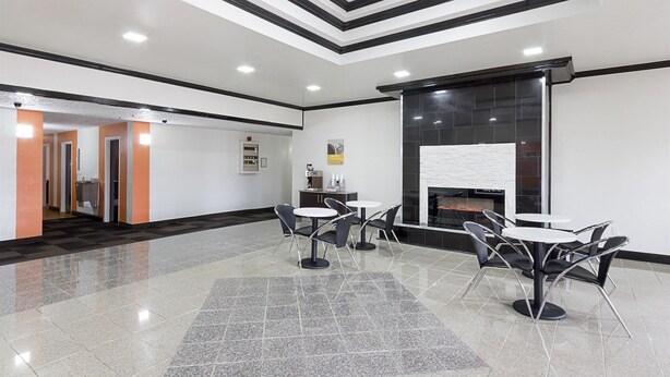 Um lobby moderno com lareira, área de estar e balcão de recepção.