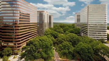 Uma área urbana moderna com edifícios altos, árvores verdes e céu claro.