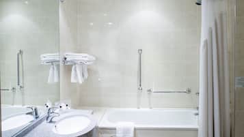Uma casa de banho moderna com duas pias, uma banheira e um chuveiro.