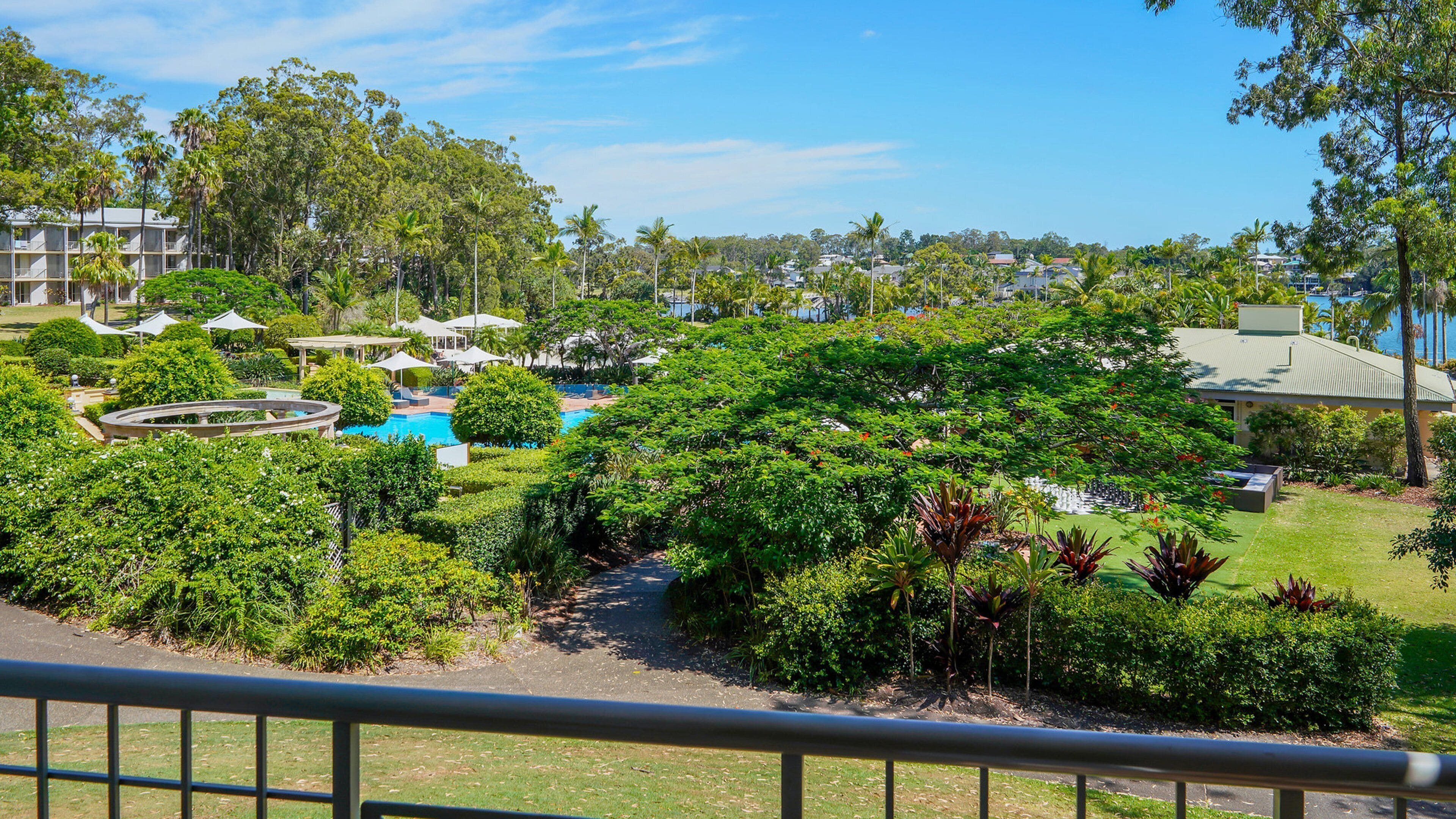 Resort com piscina, vegetação exuberante e vários edifícios.
