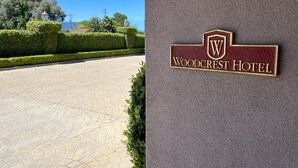 Uma trilha pavimentada que leva a um edifício com uma placa que diz 'WOODCREST HOTEL'.