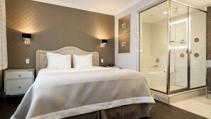 Quarto com cama, mesa de cabeceira e closet espaçoso com chuveiro.
